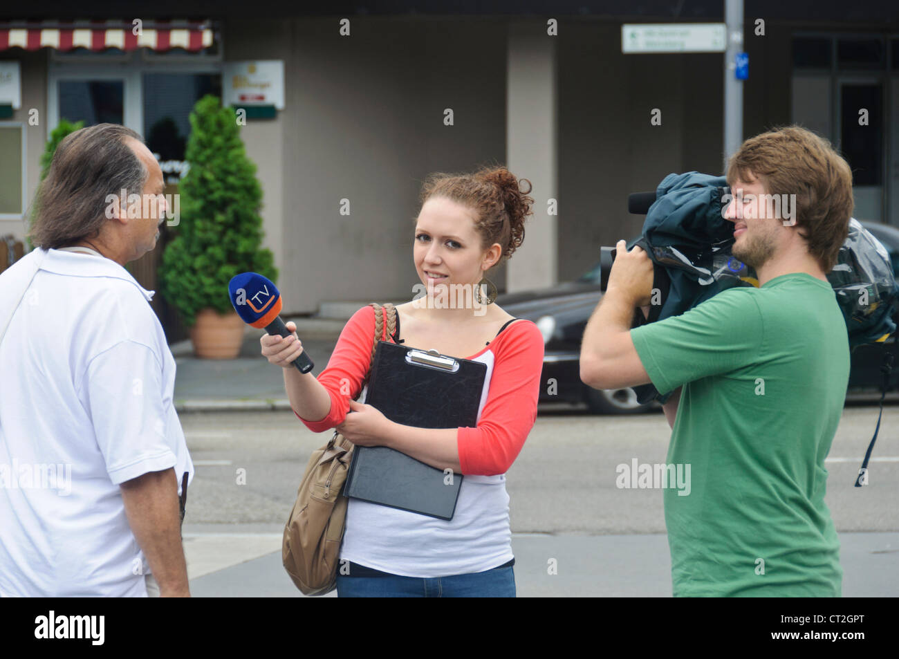 TV Team Male Cameraman Female Reporter Interview on Street interviewing Man in Public ...