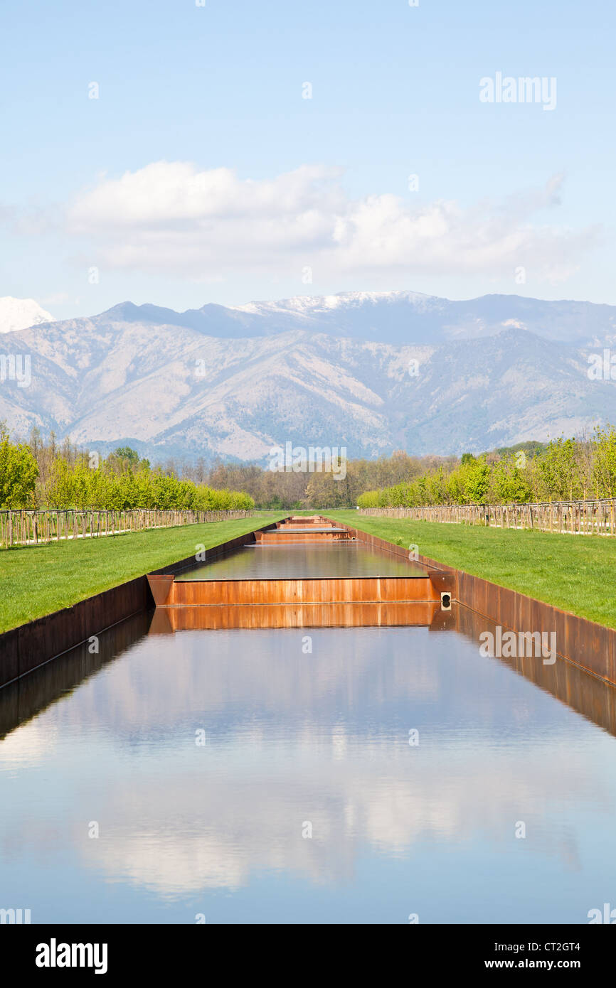 Italy - Water pool in green field with Alps mountains on background ...