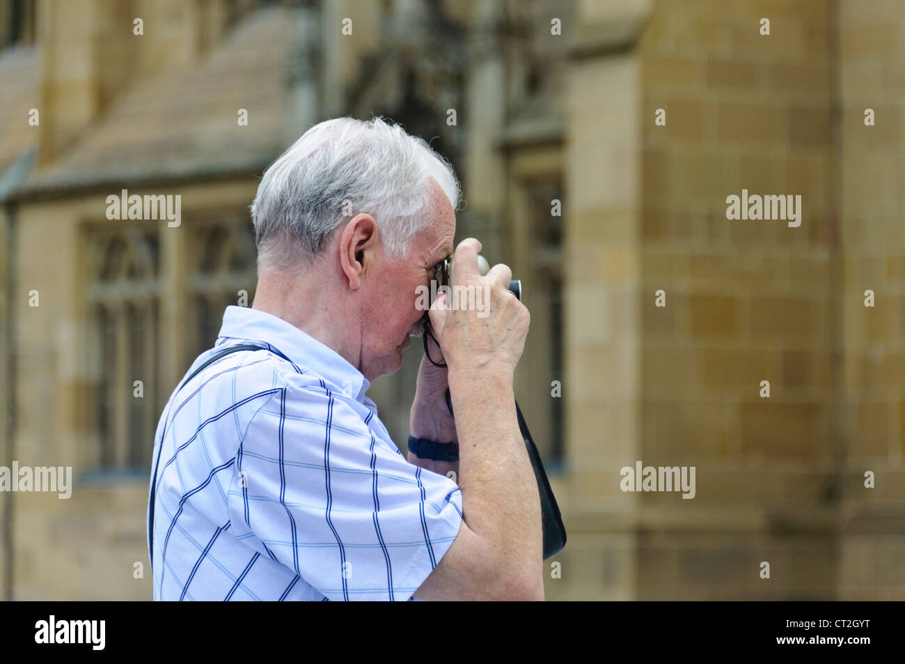 Senior Citizen Photographer with gray white hair takes pictures with ...