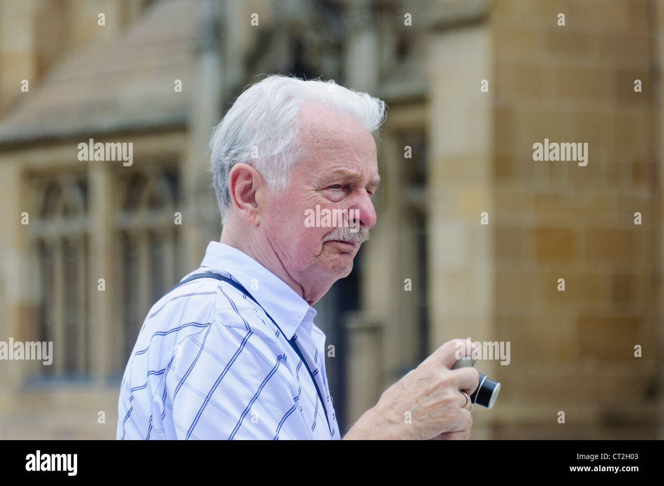 Senior Citizen Photographer with gray white hair takes pictures with ...