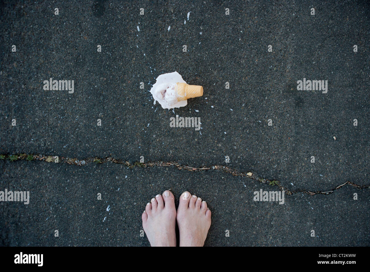 Feet with fallen ice cream cone on pavement Stock Photo - Alamy