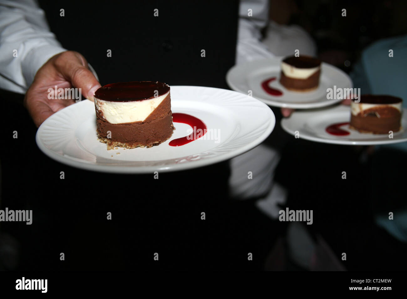 Close-up of a waiter carrying 3 plates of chocolate dessert Stock Photo ...