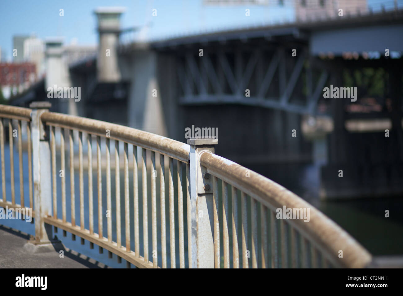 Curved steel railing with soft focus bridge and sky in Portland Oregon ...