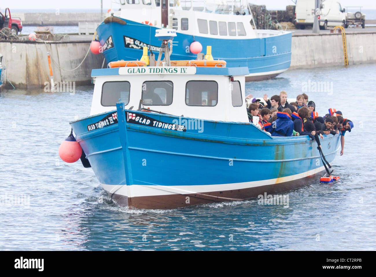 Seahouses Harbour with school children on a boat after a trip to the ...