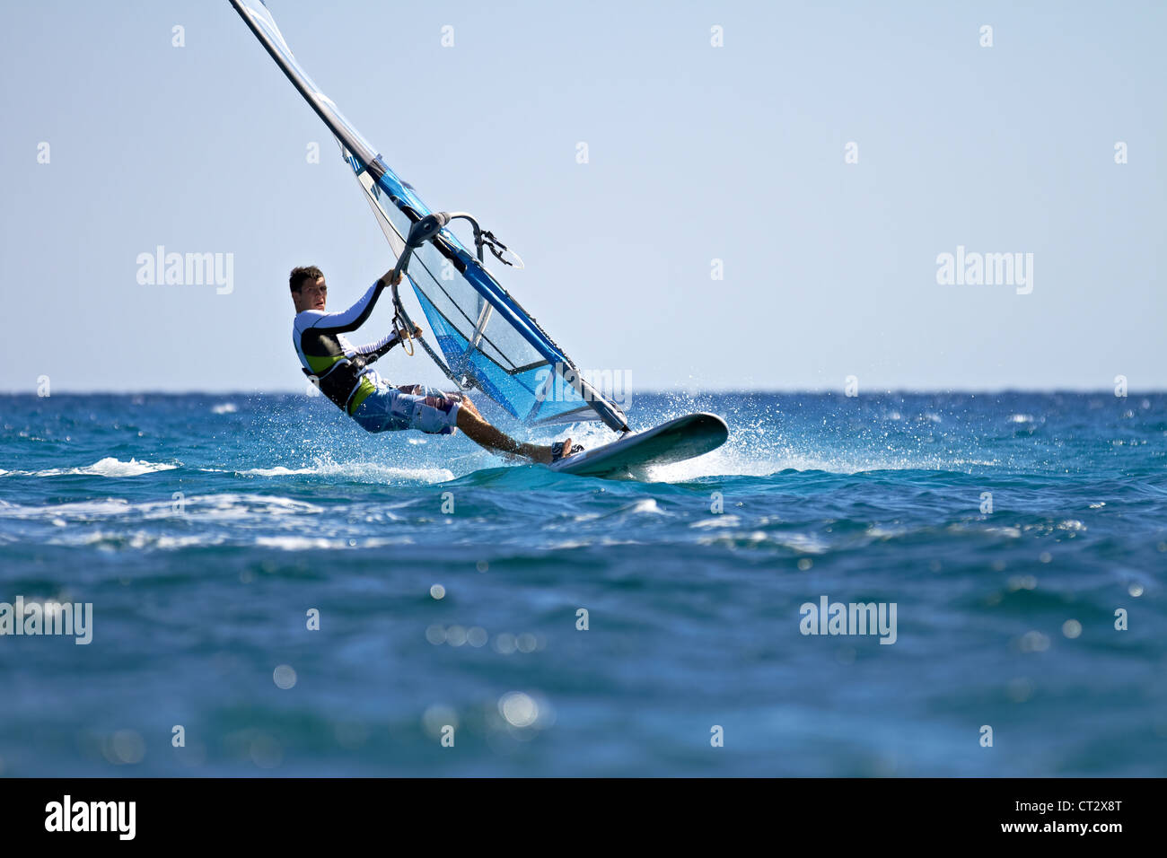 Side view of young windsurfer passing by Stock Photo - Alamy