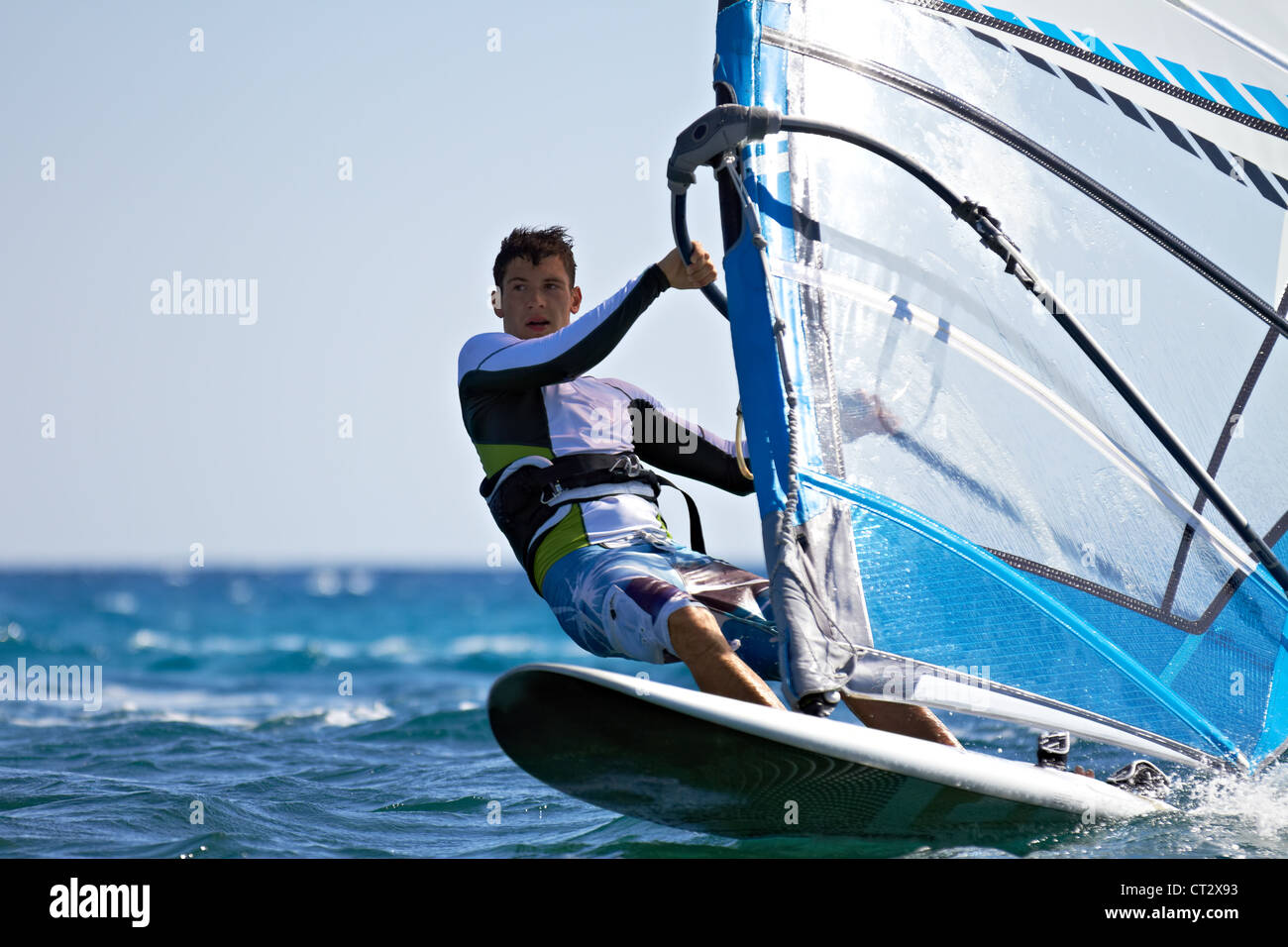 Front view of young windsurfer passing by close-up Stock Photo - Alamy