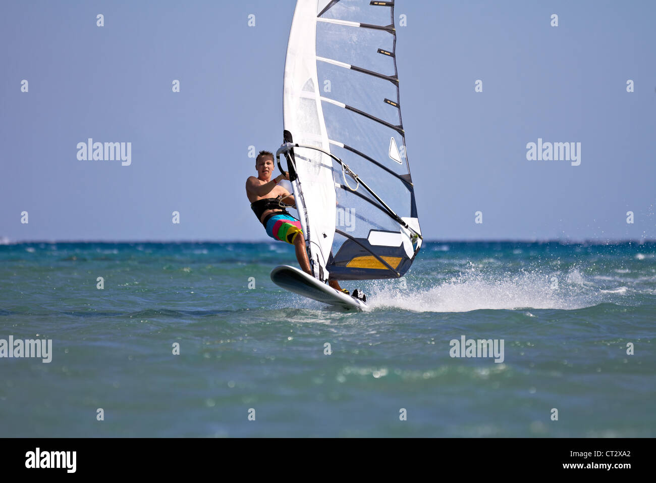 Front view of young windsurfer starting a jump Stock Photo - Alamy