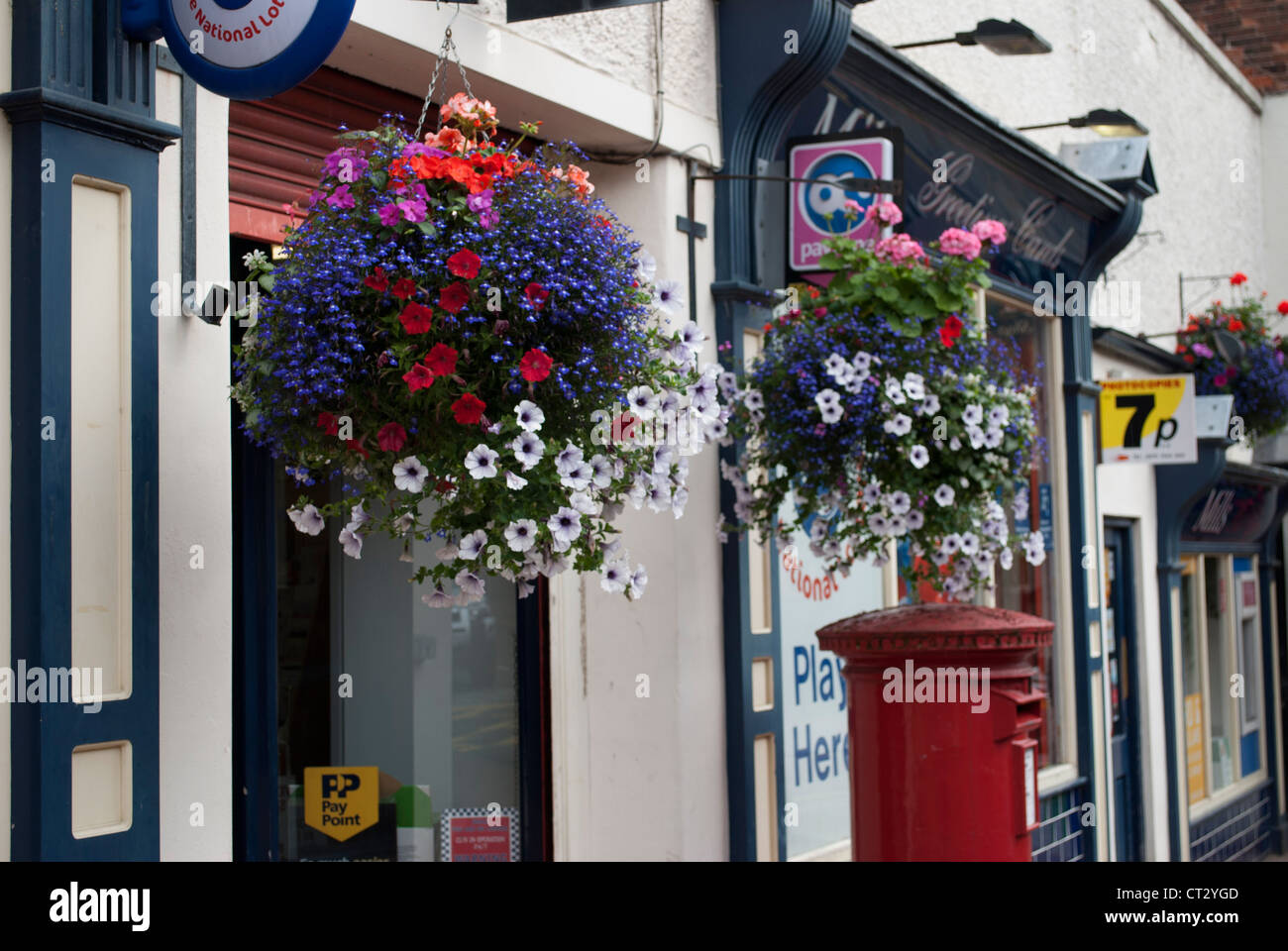 Hanging baskets outside post office shop with pillar box Stock Photo ...