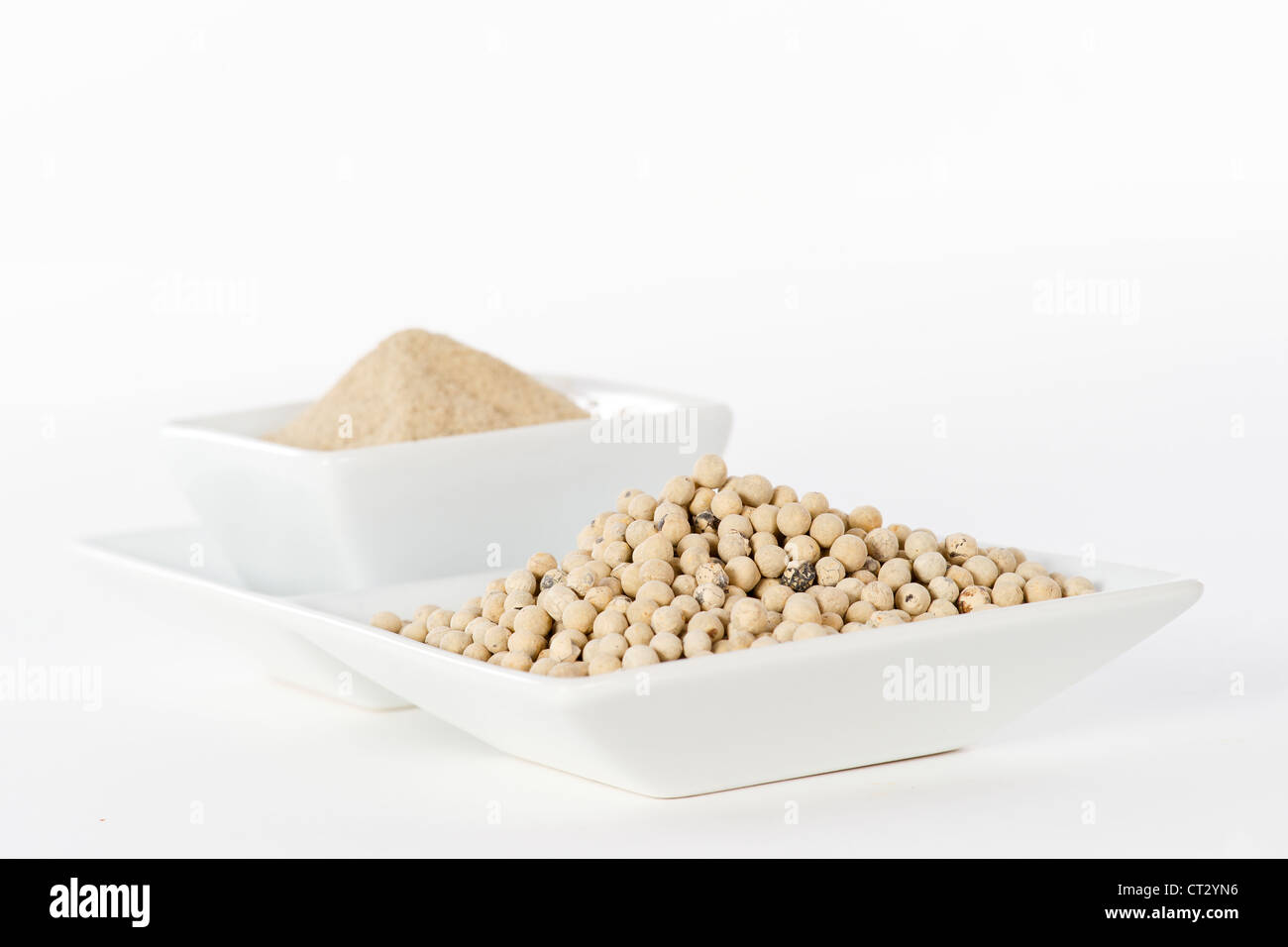 White pepper grain and powder on ceramic bowl Stock Photo - Alamy