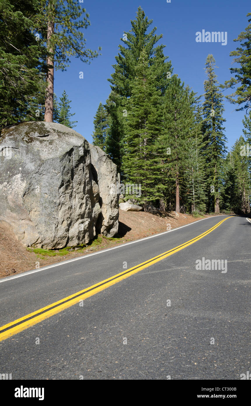 road with rock split in half in Yosemite National Park in California ...