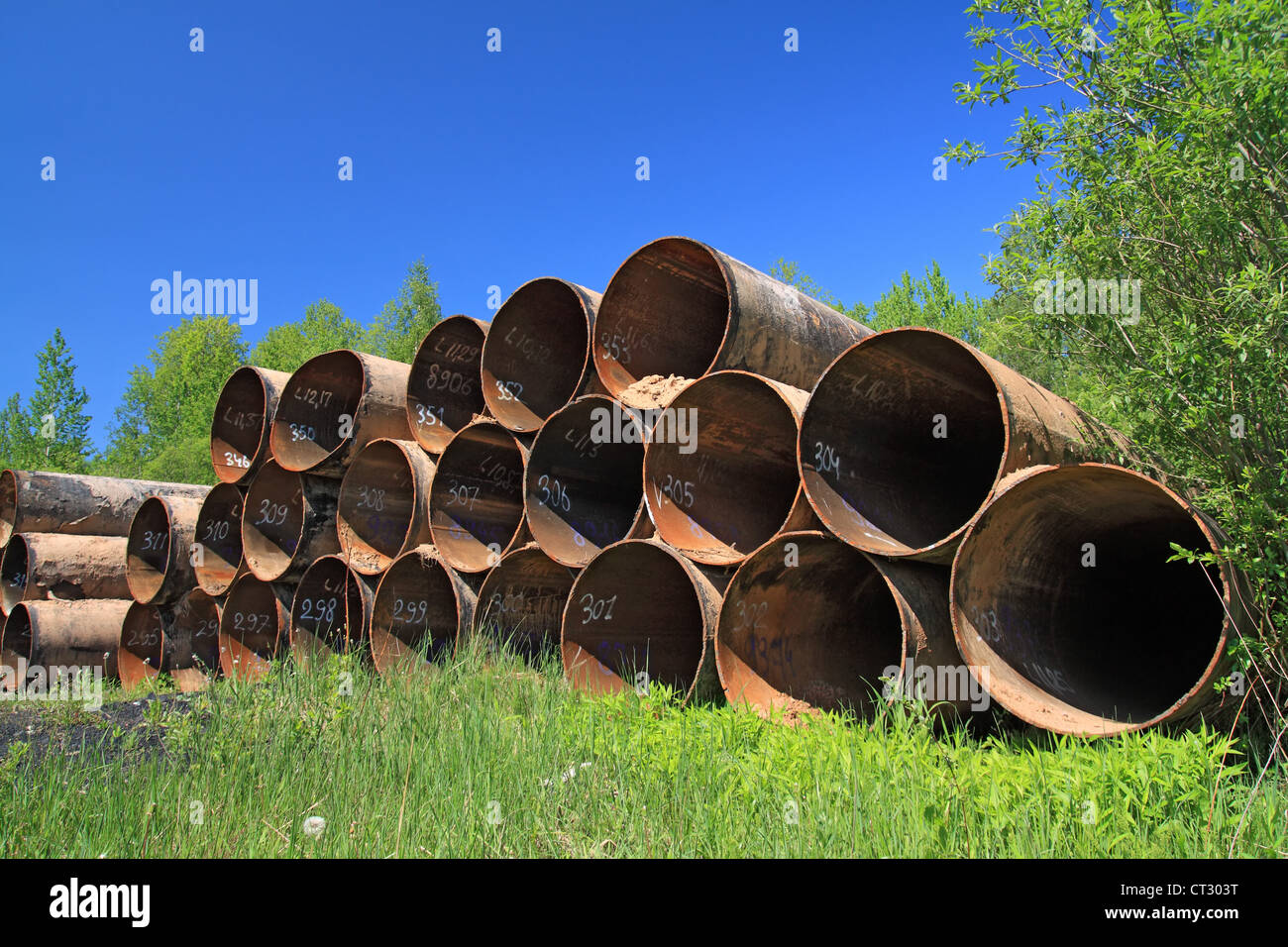 old gas pipes amongst green herb Stock Photo - Alamy