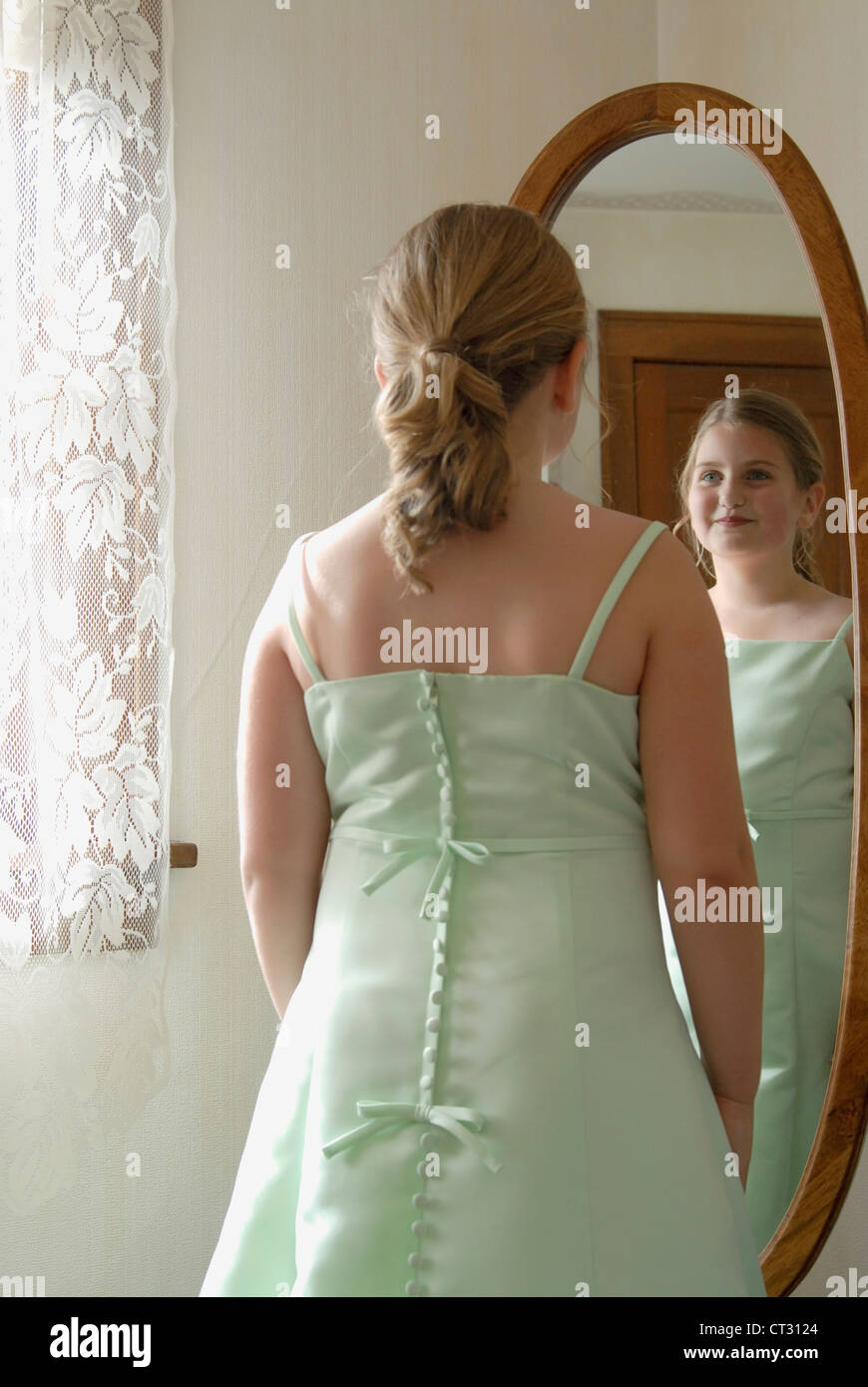 A young girl looking at her reflection in a mirror Stock Photo - Alamy