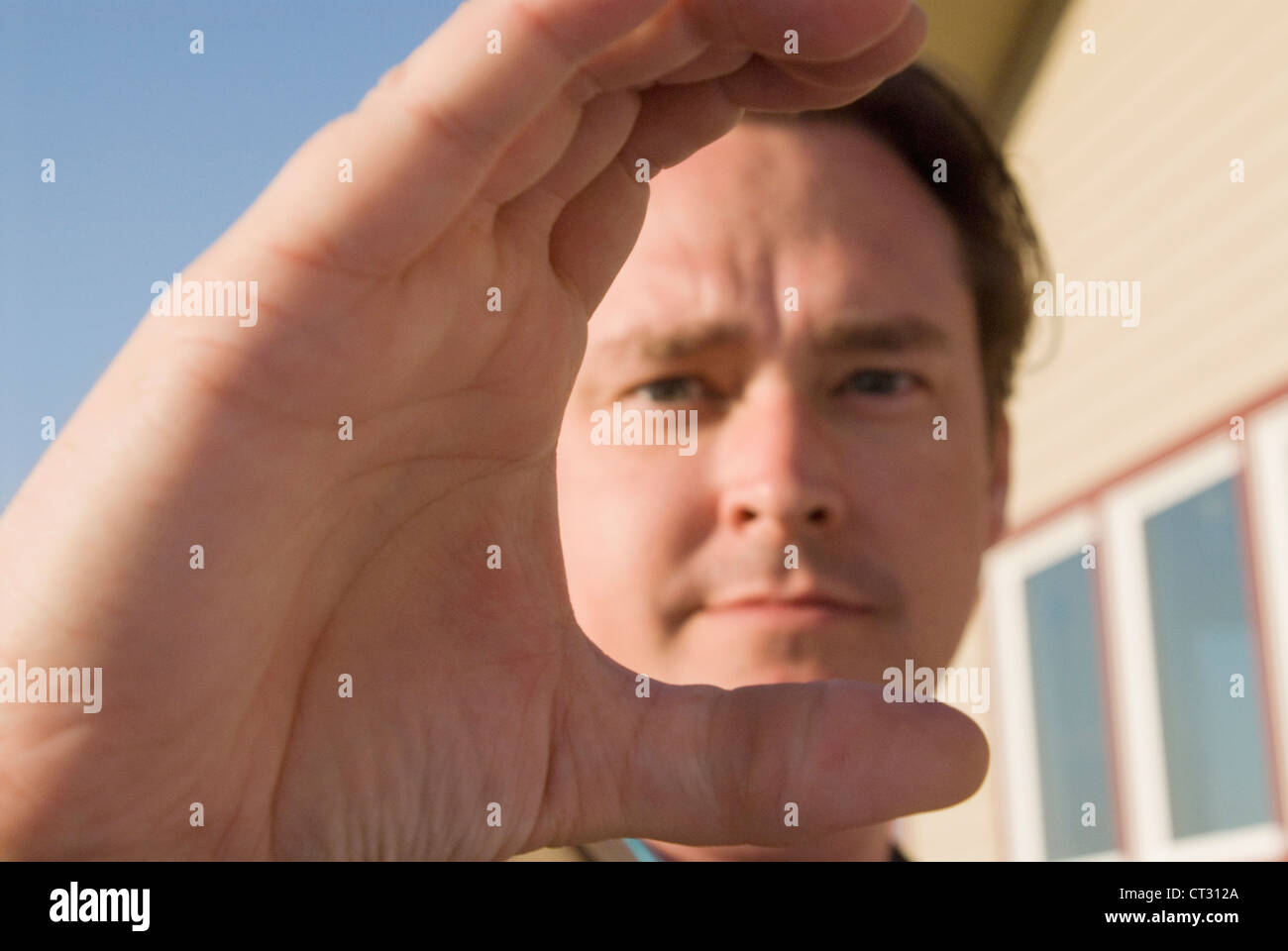 A man looking through hand for size Stock Photo - Alamy
