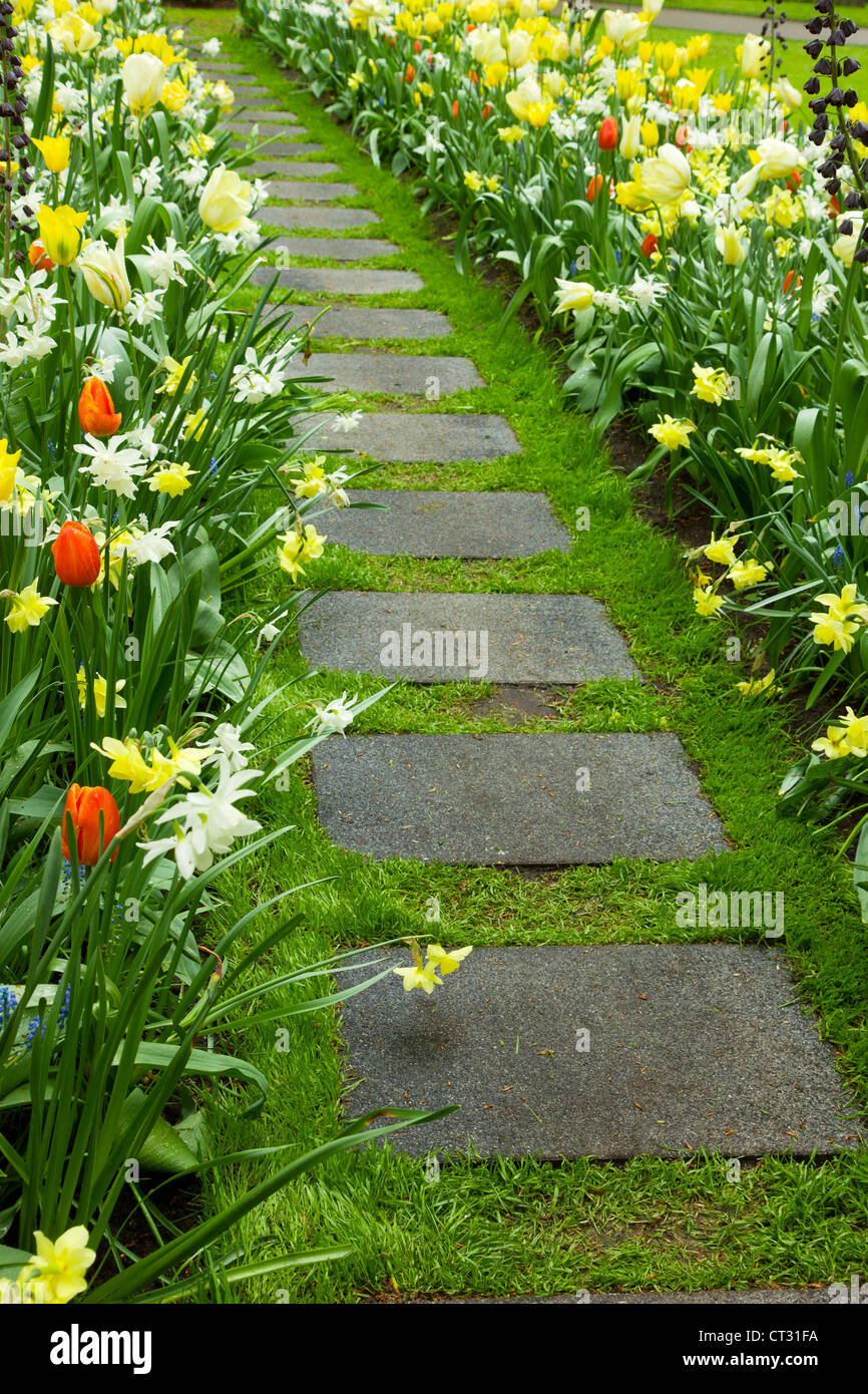 Stone walk way winding in flower garden Stock Photo - Alamy