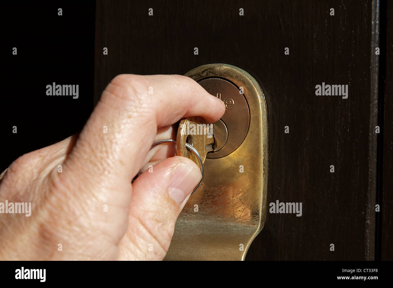 Hand putting key in door hi-res stock photography and images - Alamy