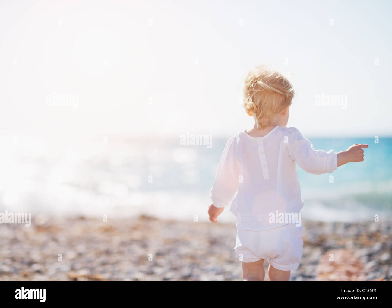 Baby walking on beach. Rear view Stock Photo - Alamy