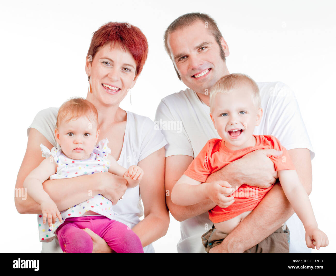 happy parents with their two children looking at the camera, smiling ...