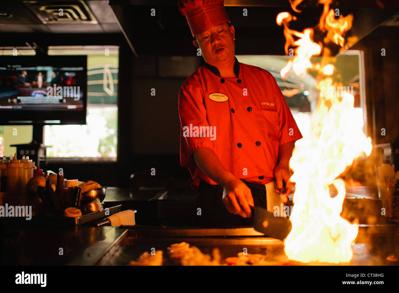 Japanese chef cooking in the bar with fire and flames Stock Photo - Alamy