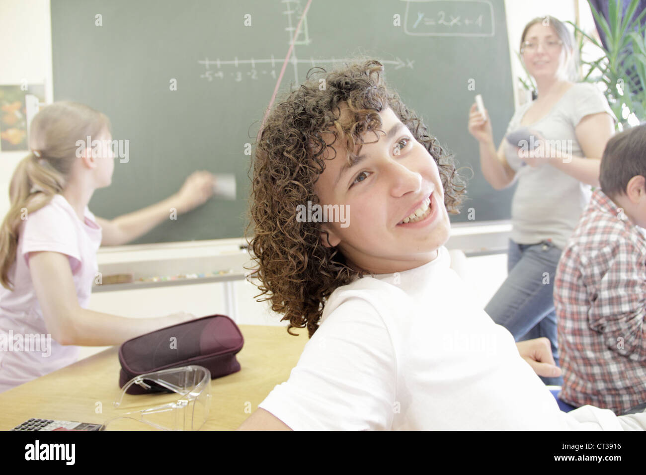 Student smiling in class Stock Photo - Alamy