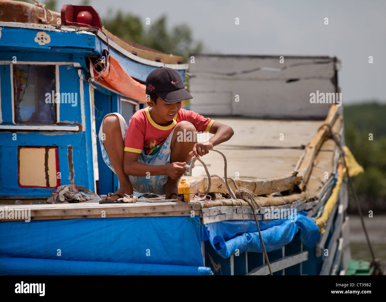 Young boy attaching a boat on Than Anh Island, near Vung Tau, Vietnam ...
