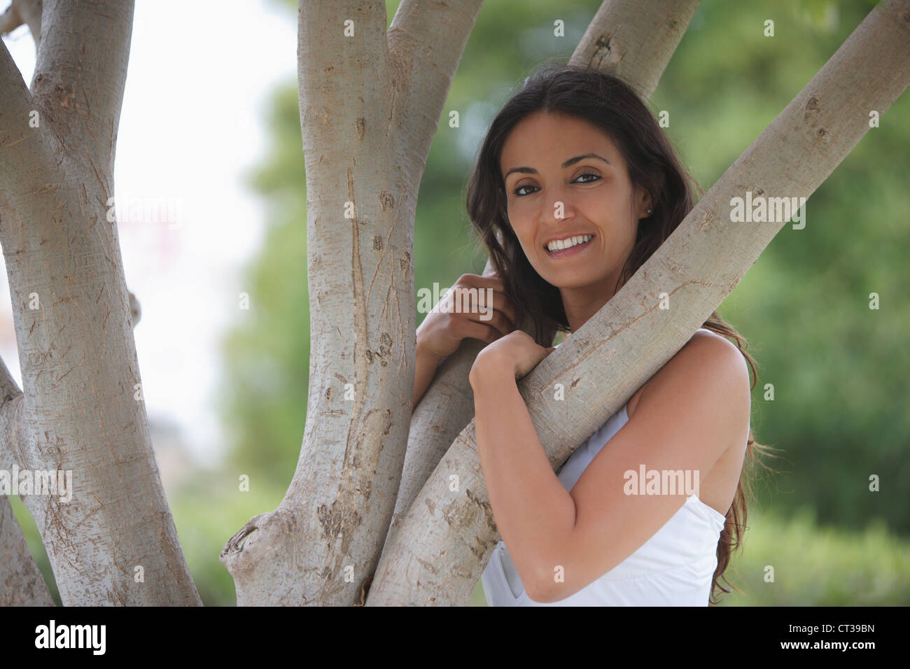 Smiling woman playing in tree Stock Photo - Alamy