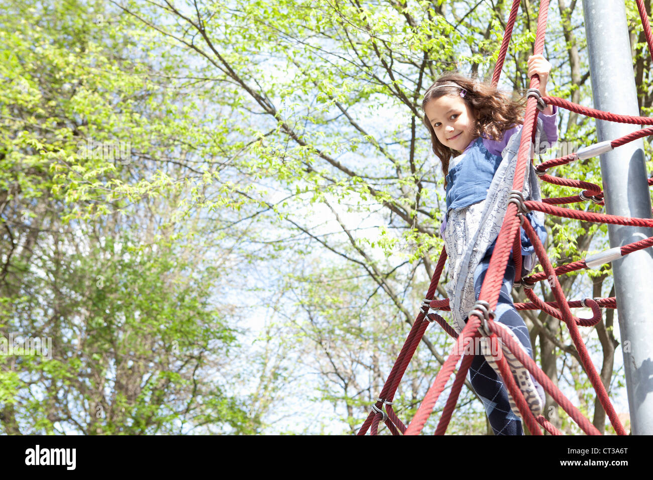 Girl climbing ropes in playground Stock Photo - Alamy