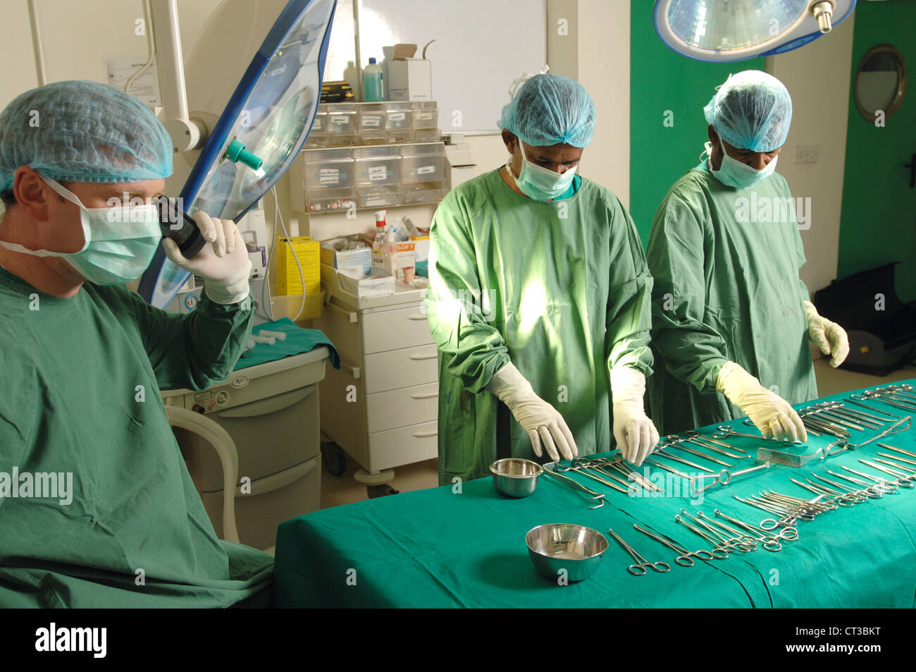 Surgical theatre staff laying out various surgical tools on the ...
