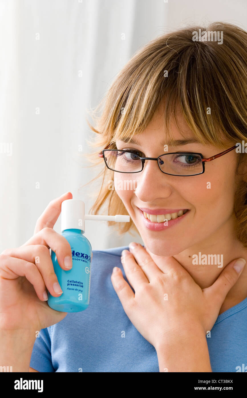 WOMAN USING SPRAY IN MOUTH Stock Photo - Alamy