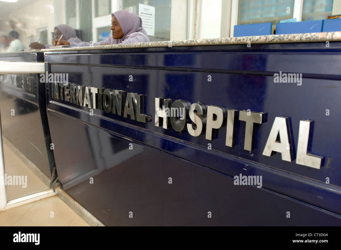 A receptionist manning the reception desk of an International Hospital ...