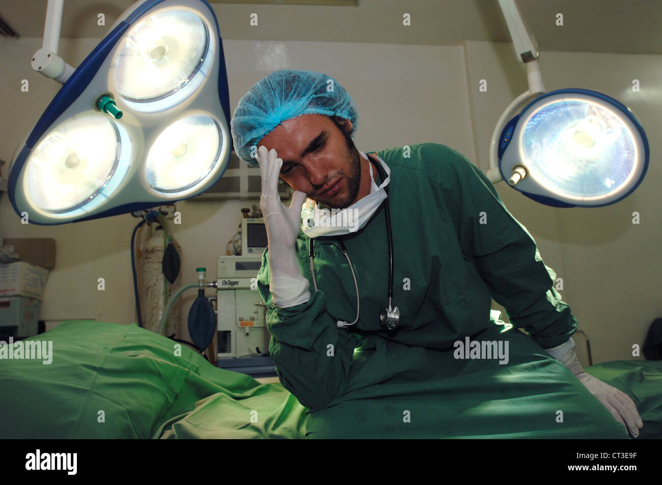 An exhausted surgeon at the end of a long session in the operating ...