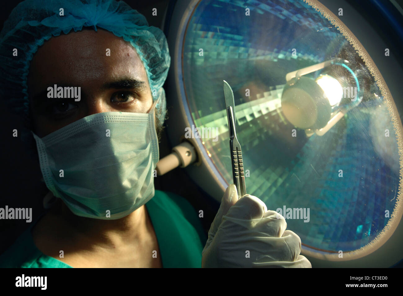 Close-up of a surgeon holding a scalpel up to an operating theatre ...