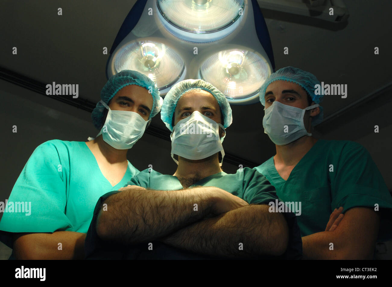 Three surgeons standing underneath a theatre light Stock Photo - Alamy