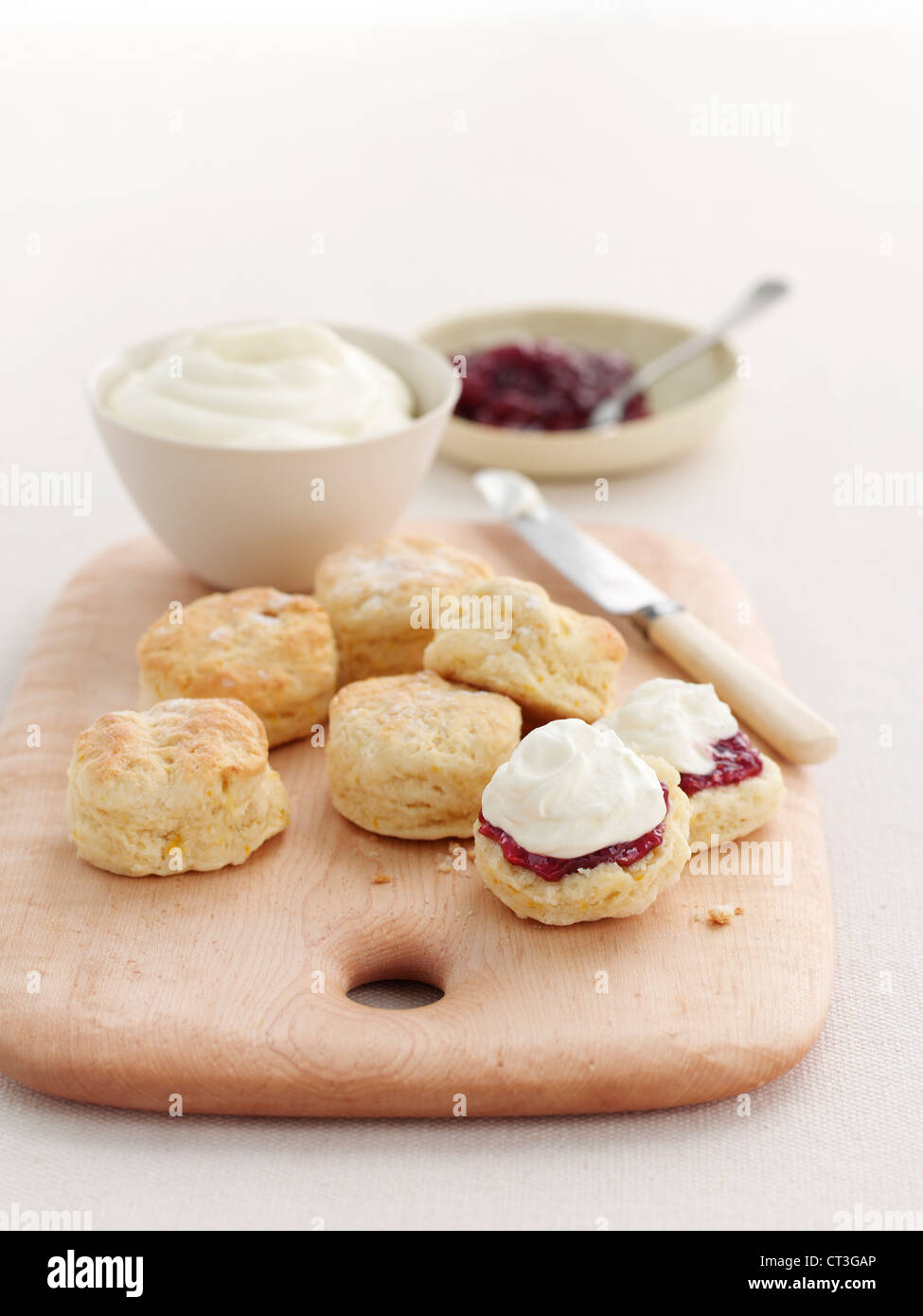 Scones with cream and jam on board Stock Photo - Alamy