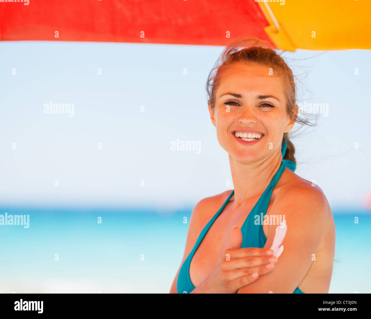 Happy woman applying sun block creme on arm Stock Photo - Alamy