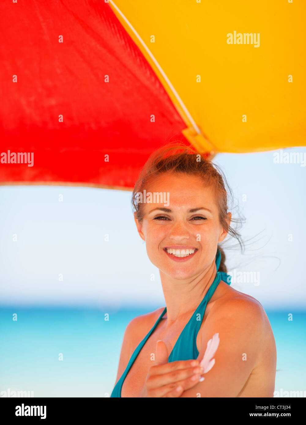 Smiling woman applying sun block creme on arm Stock Photo - Alamy