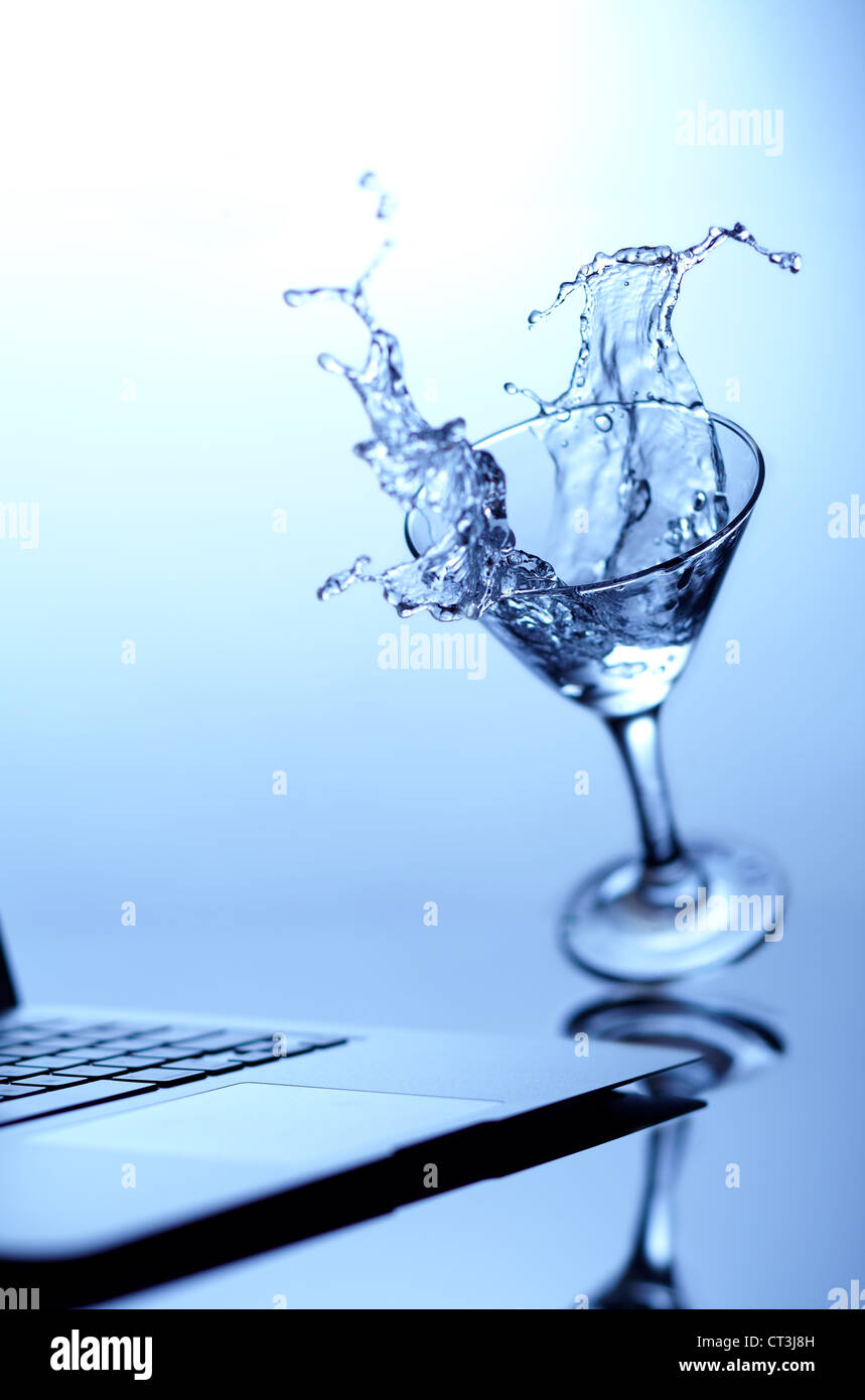 Cocktail spilling on laptop Stock Photo - Alamy