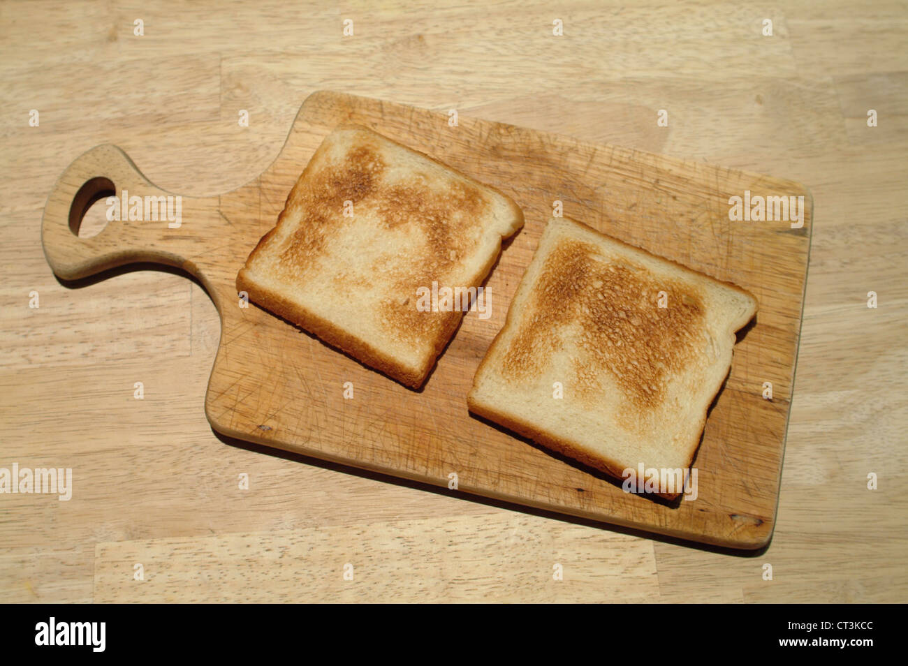 Two slices of toast lying on a wooden board Stock Photo - Alamy