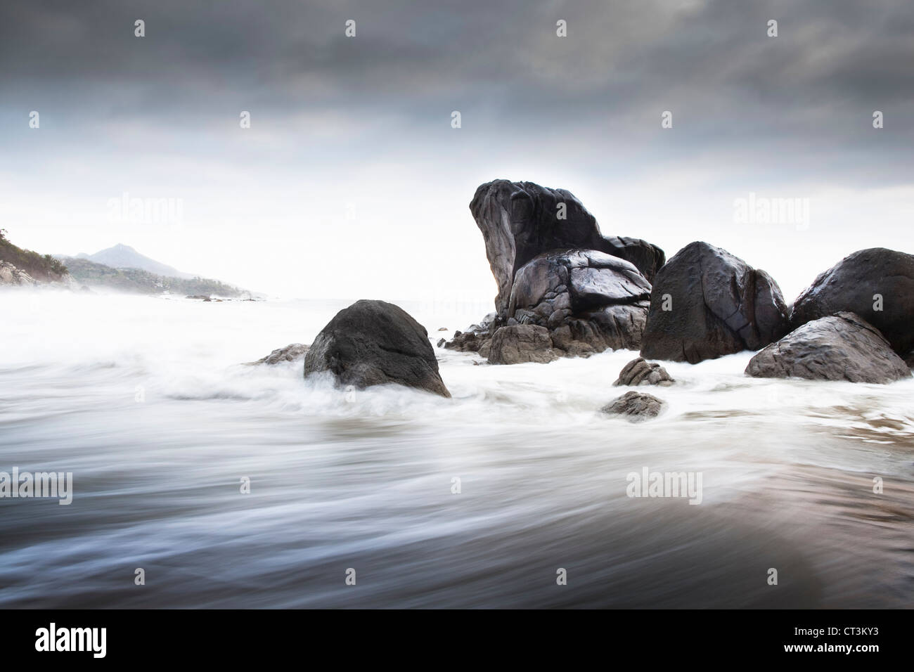 Waves washing over rocks on beach Stock Photo - Alamy