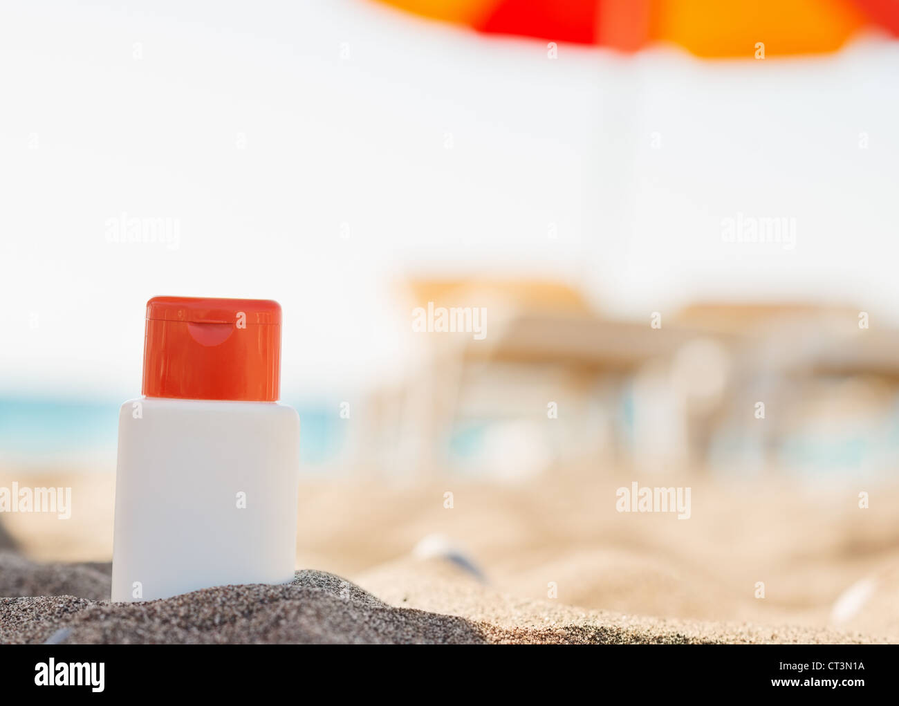 Bottle of sun block creme in shadow on beach Stock Photo - Alamy