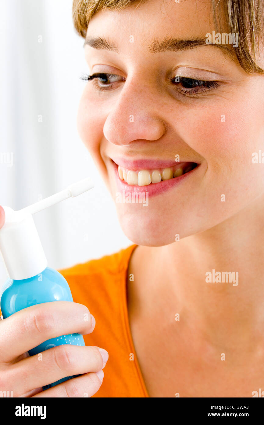 WOMAN USING SPRAY IN MOUTH Stock Photo - Alamy
