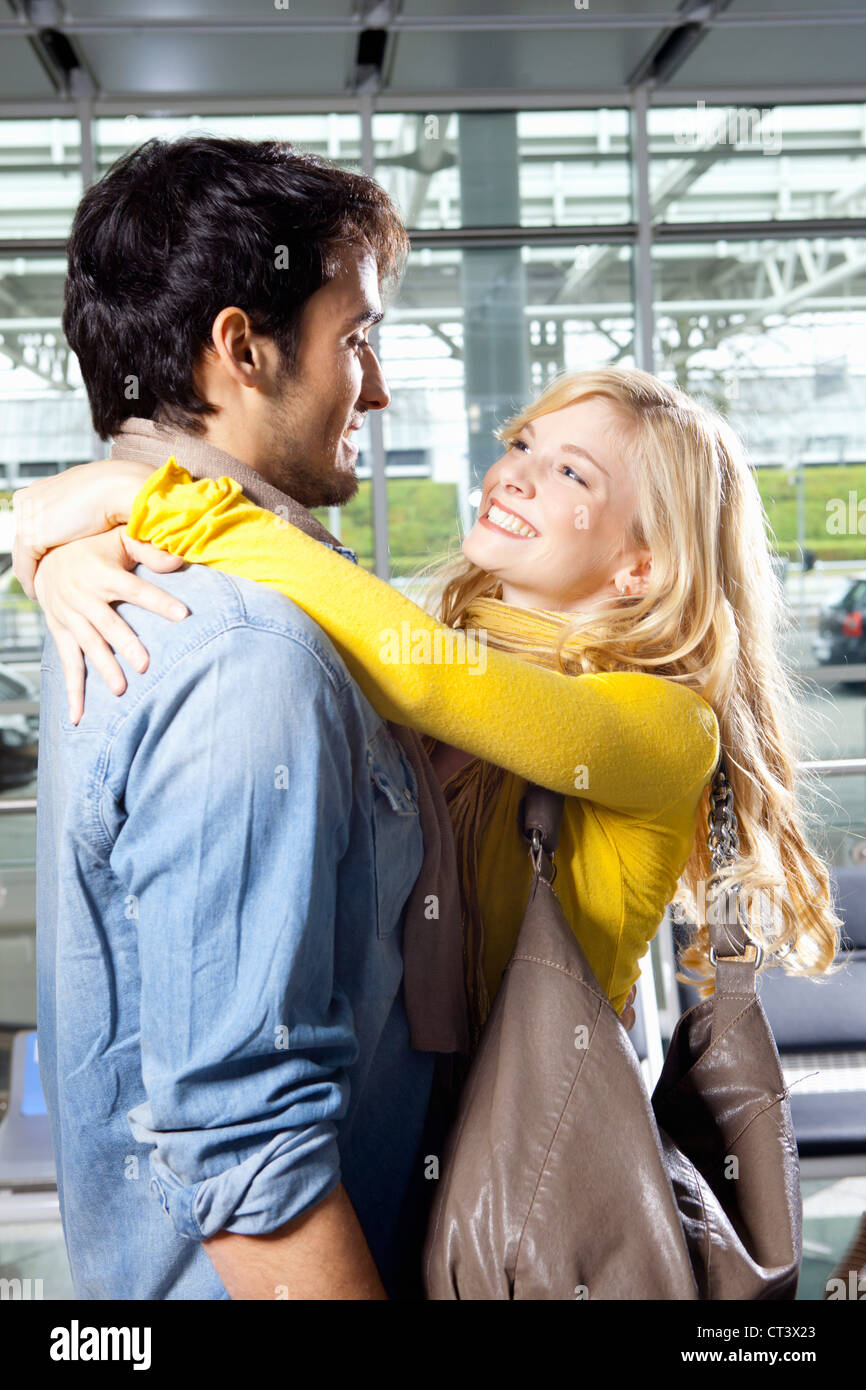 Couple hugging in airport Stock Photo - Alamy