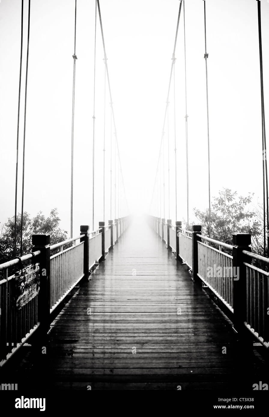 view on pedestrian wooden bridge in mist Stock Photo - Alamy