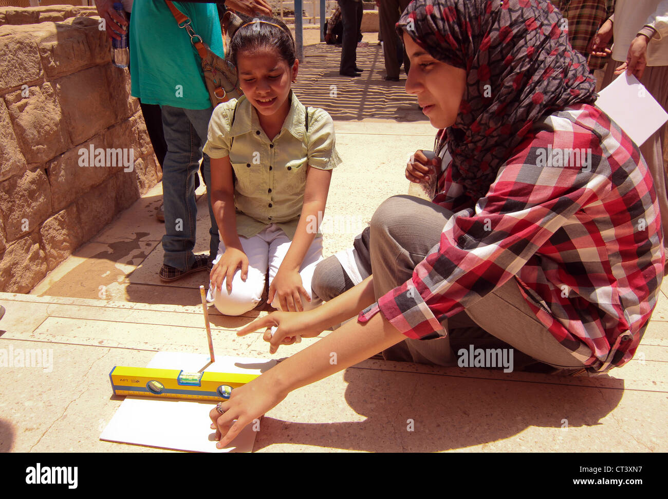 School children from Aswan conduct experiments using pencils to show ...