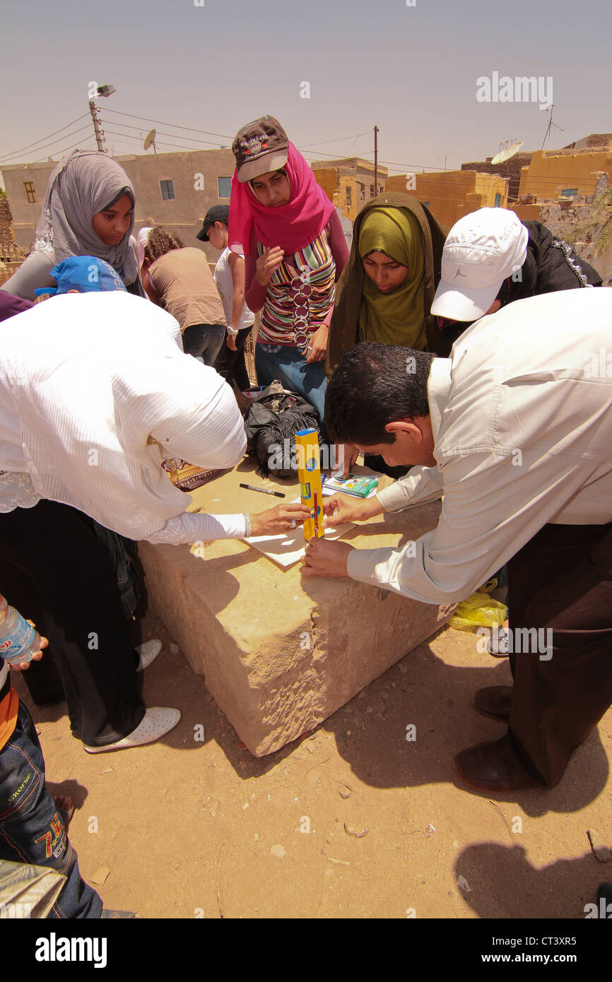 School children from Aswan conduct experiments using pencils to show ...