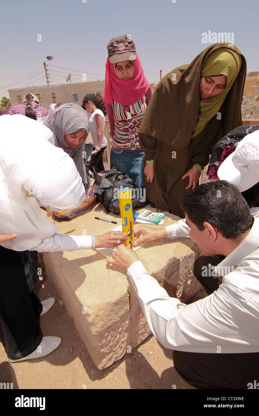 School children from Aswan conduct experiments using pencils to show ...