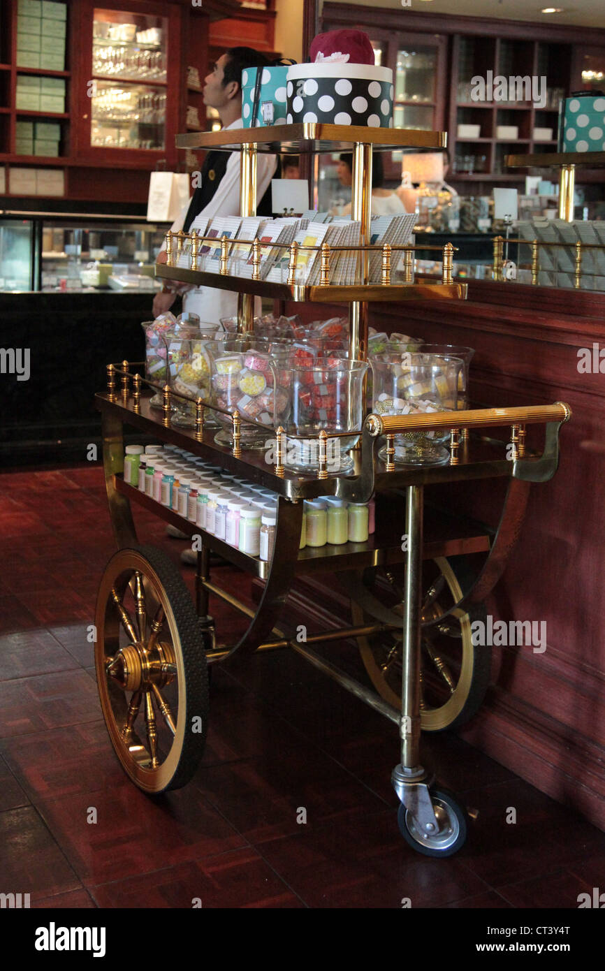 It's a photo of a old style trolley with sweet goods on sale on it. It ...
