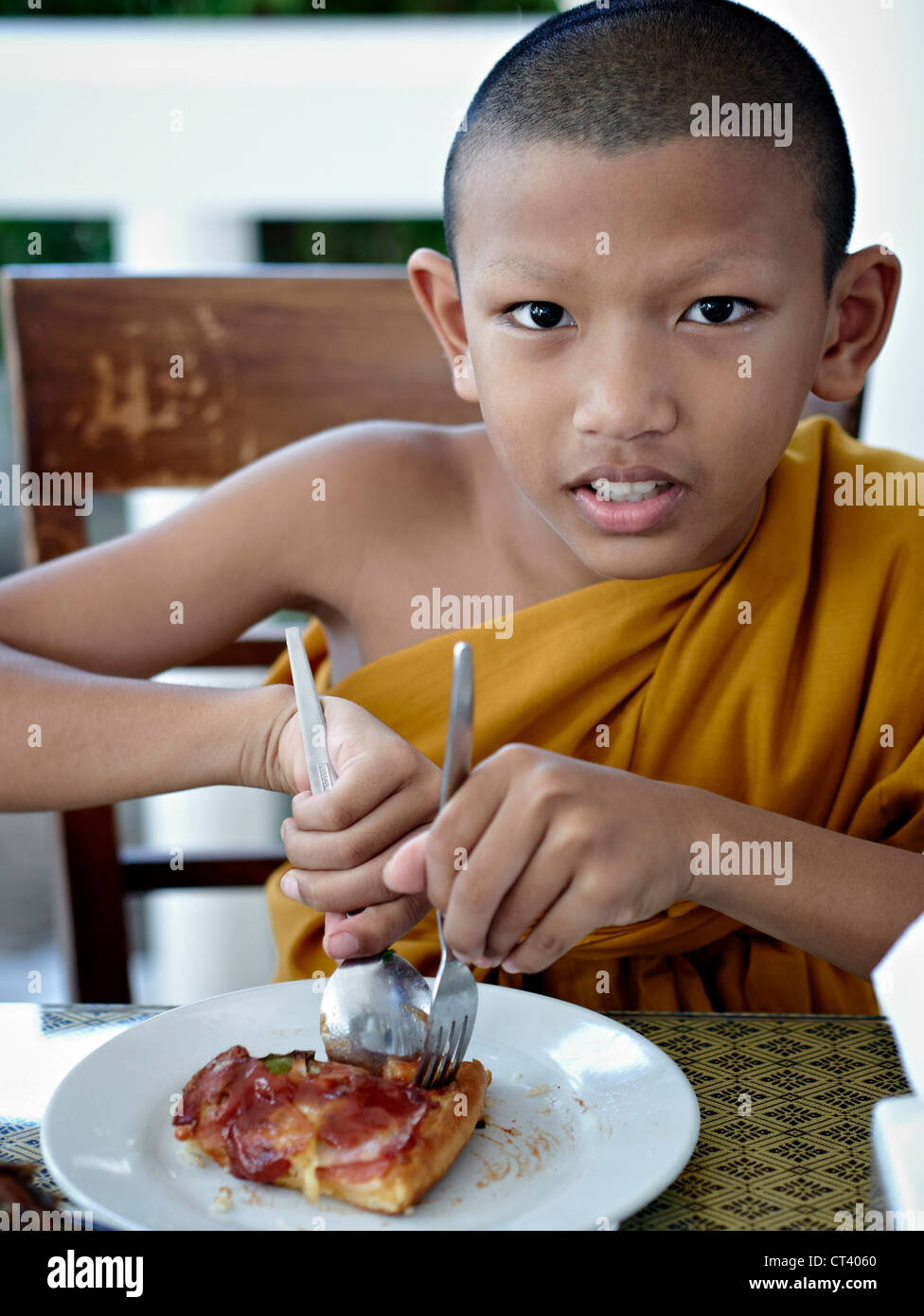 Young Thai Buddhist monk at lunch eating pizza. Thailand S.E. Asia ...