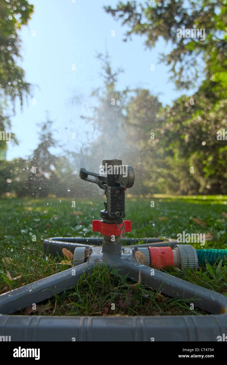 Automatic water sprinkler used for grass lawn irrigation on a very hot ...