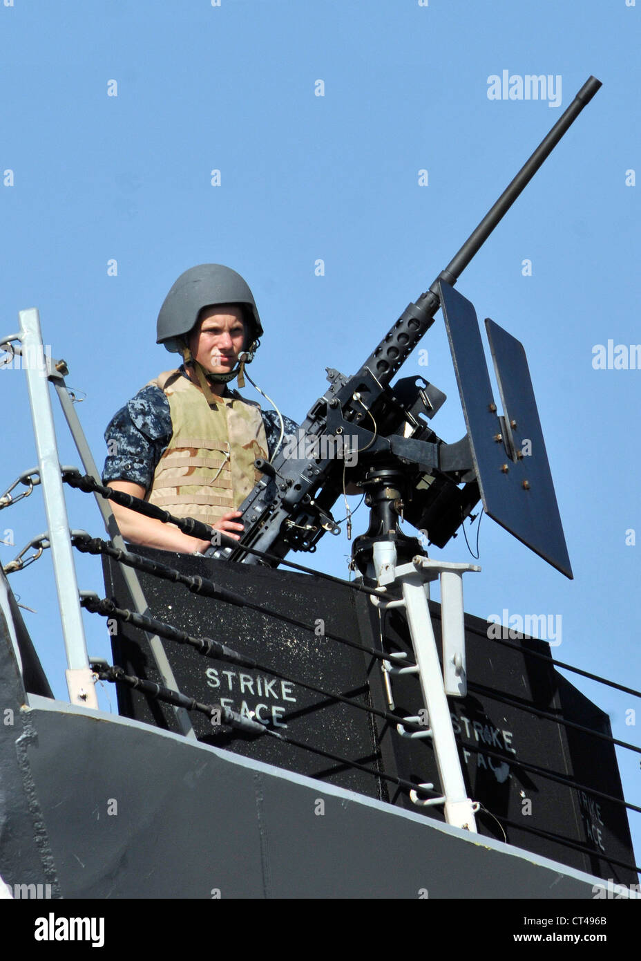 A Sailor mans a .50 caliber machine gun as the guided missile destroyer ...