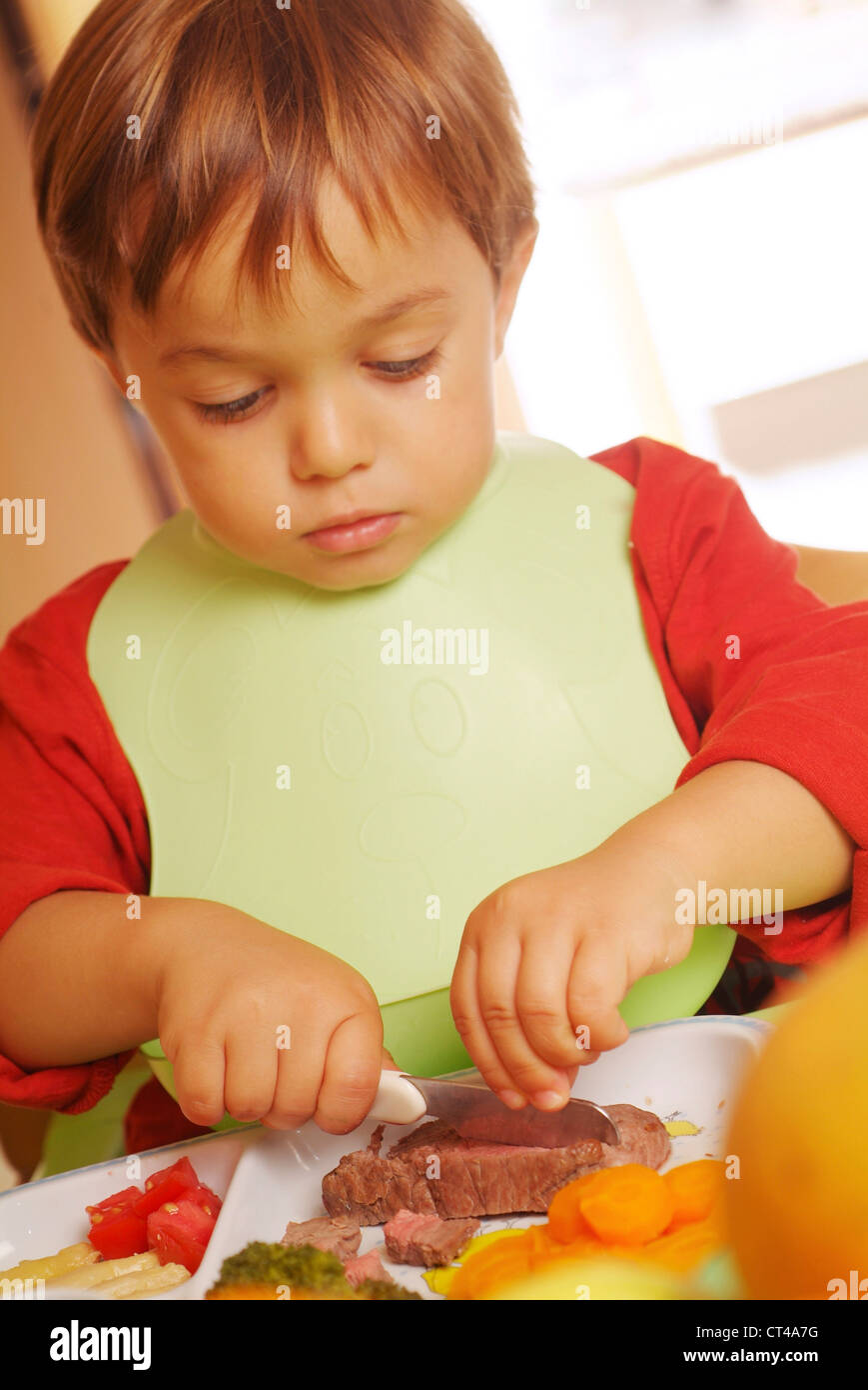 CHILD EATING MEAT Stock Photo - Alamy